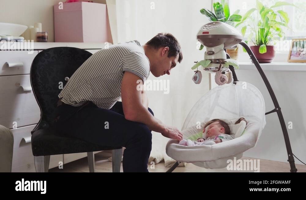 Father rocking the cradle Stock Video Footage - Alamy