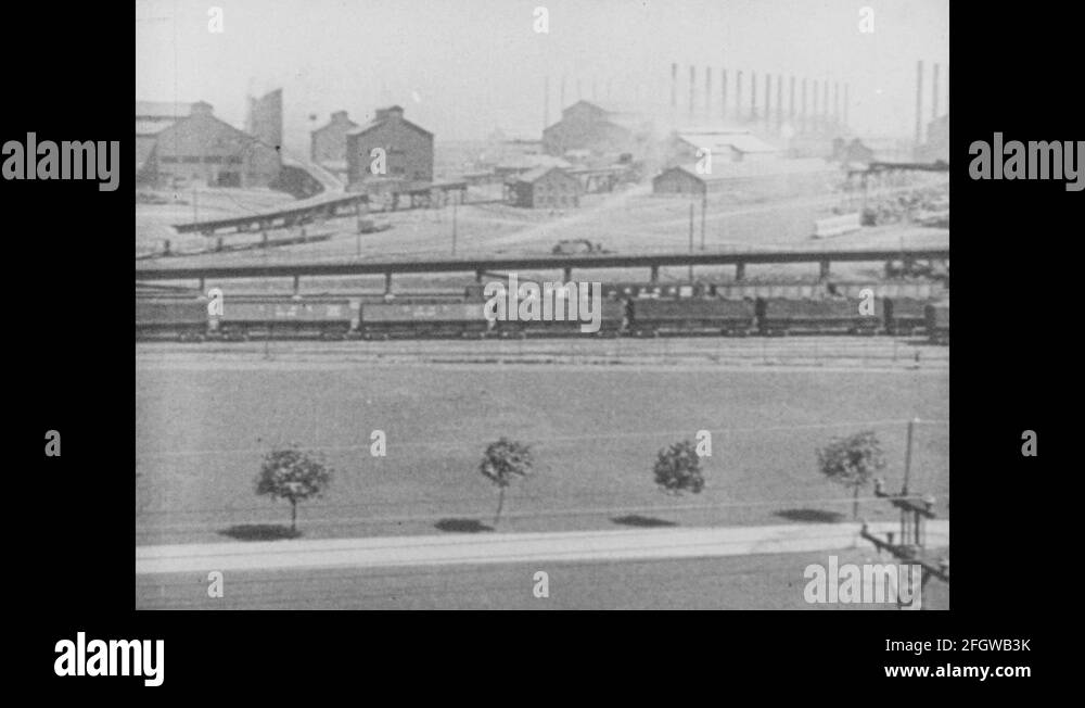 1930s: Steam train carries freight cars to factory. Steam train carries ...