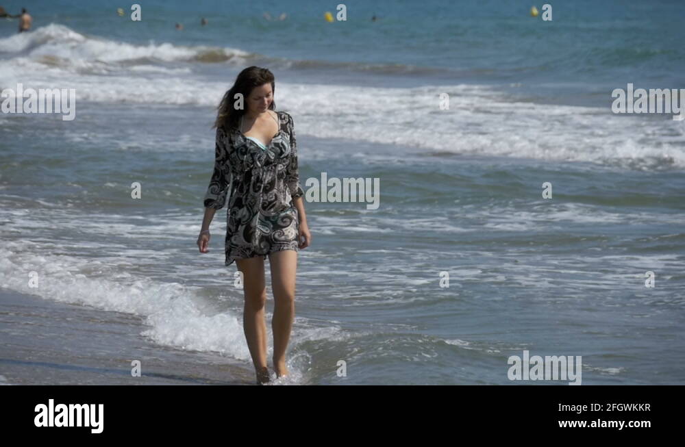 Girl in bathing suit runs along the sea shore at the beach in Slow ...