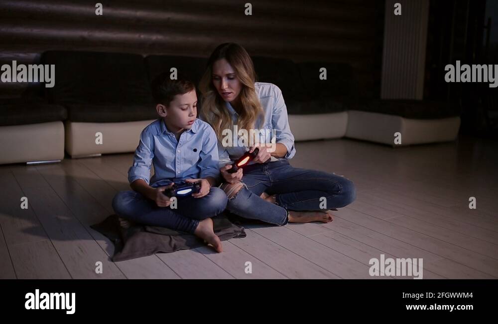 Beautiful mother with her son playing video games on gaming console in ...