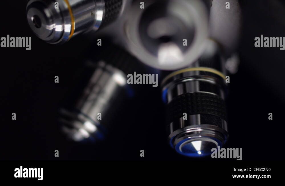 Objectives of the microscope approach the objective glass with black ...