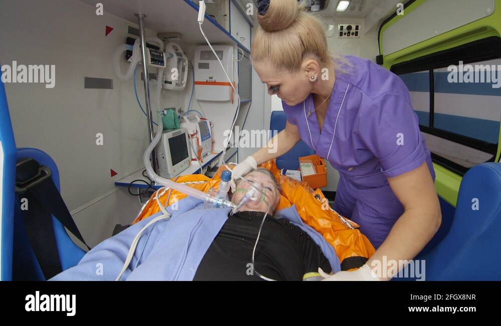 Emergency medical service. Female EMS paramedic treating patient in ...