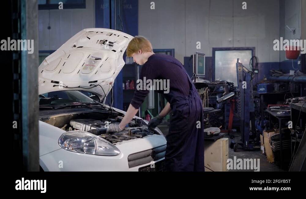 motor mechanic is diagnosing automobile during inspection and entering ...