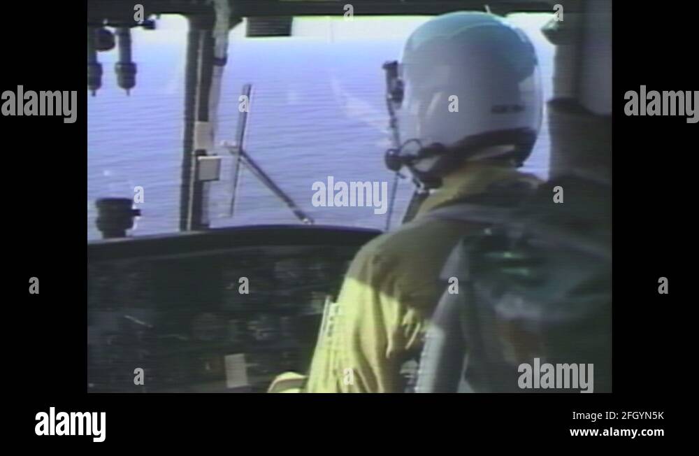 1970s: Pilot looking out cockpit window over ocean. Instruments in ...