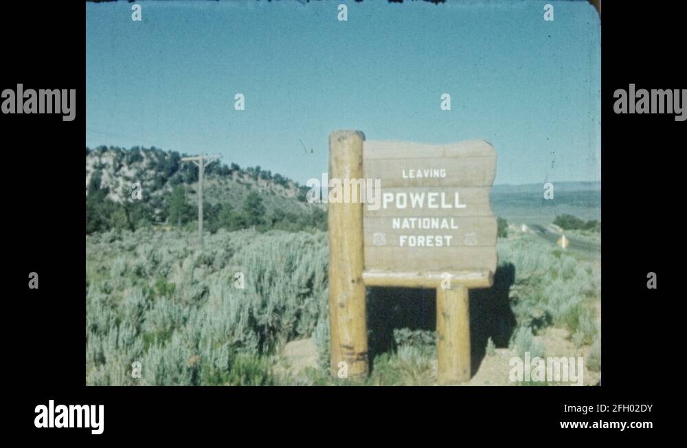 1940s: Wooden sign "Leaving Powell National Forest". Red rocks on the ...
