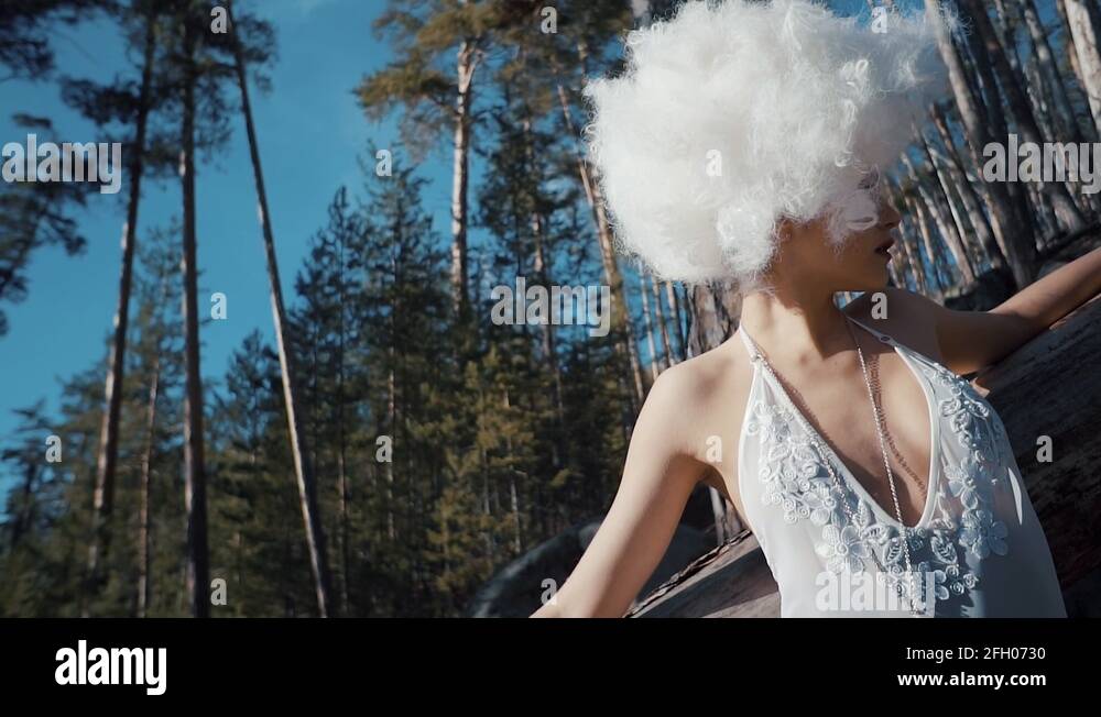 Angel girl is fallen from heaven in a pine forest, standing in daytime ...