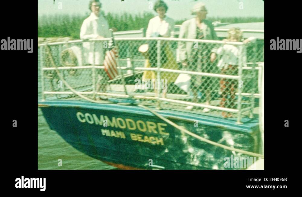 1940s: Three women and girl stand behind chain-link fence on boat. Navy ...