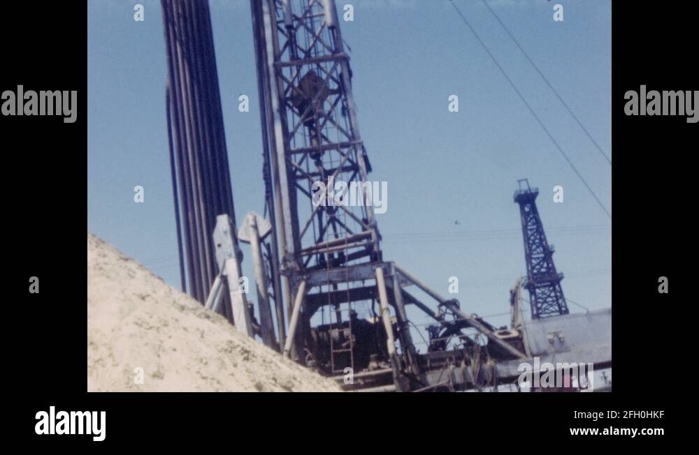1940s: Large pulley raises steel rods up through crane, man at top of ...