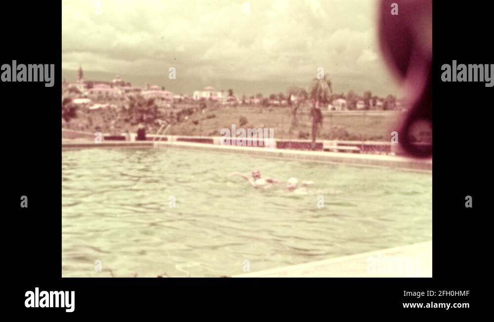 1930s: women in bathing caps and man swim and float around pool with ...