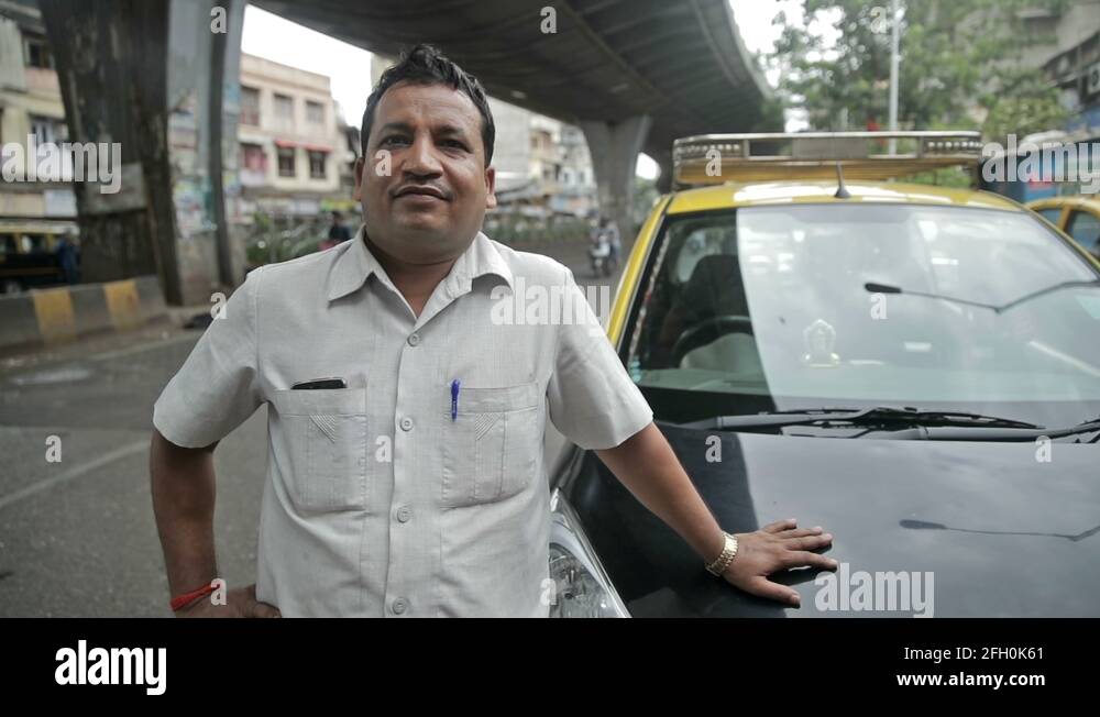 An Indian smiling taxi driver standing in front of his taxi, Mumbai ...