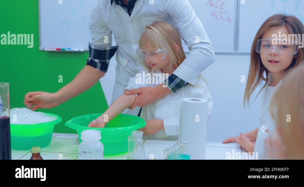 Teacher teaching group of students in school science class. Education ...