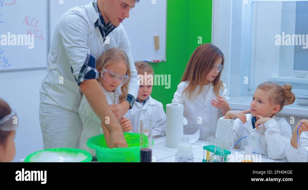 Teacher and students doing science experiment in school classroom ...