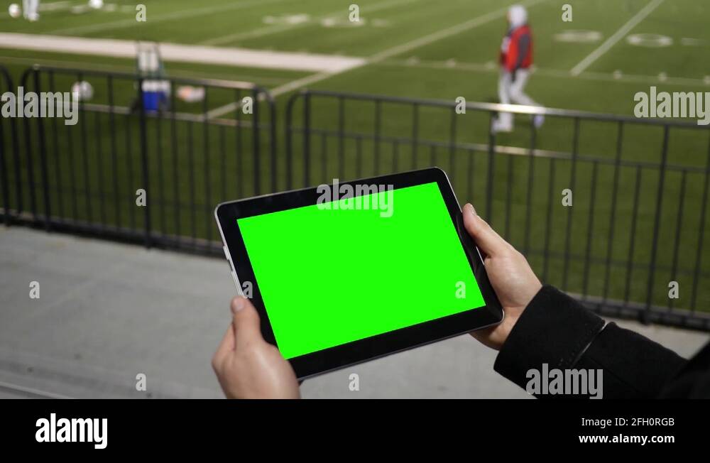 Man watches Green Screen Tablet at a Football Team Practice Session ...