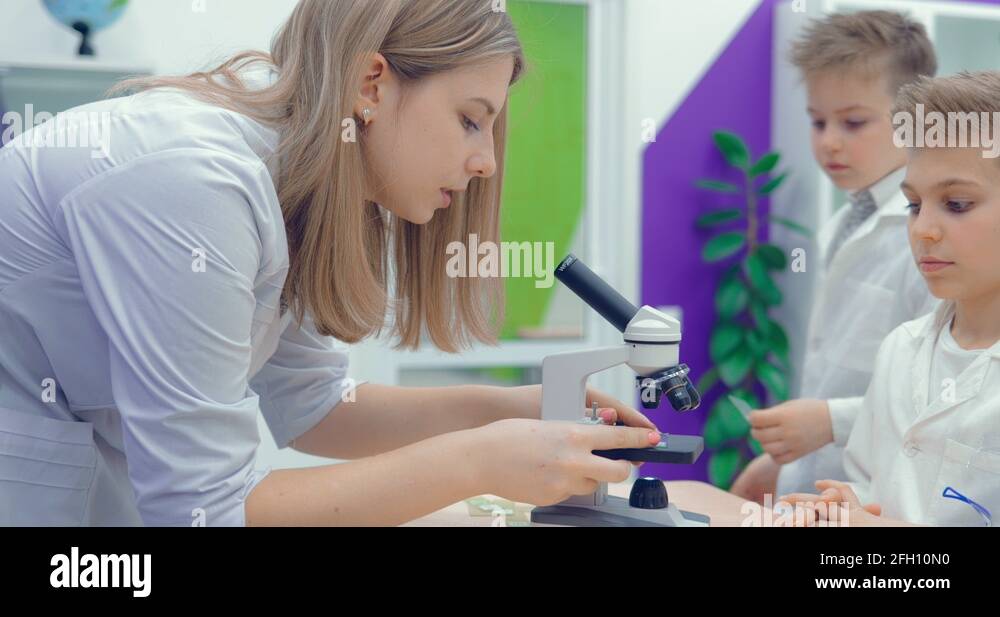 Teacher helps students create a laboratory microscope for work Stock ...