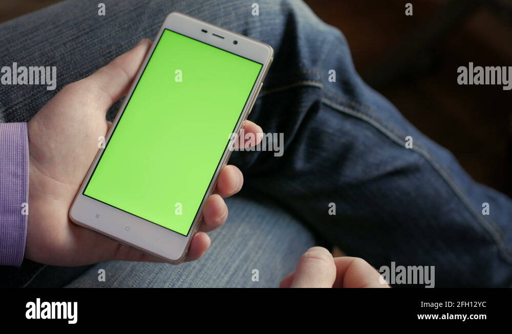 Man in the workplace using his smartphone with green screen, scrolling news Stock Video Footage ...