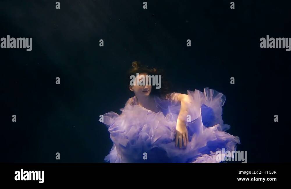 young sea sprite is underwater is swimming to surface, moving hands and ...