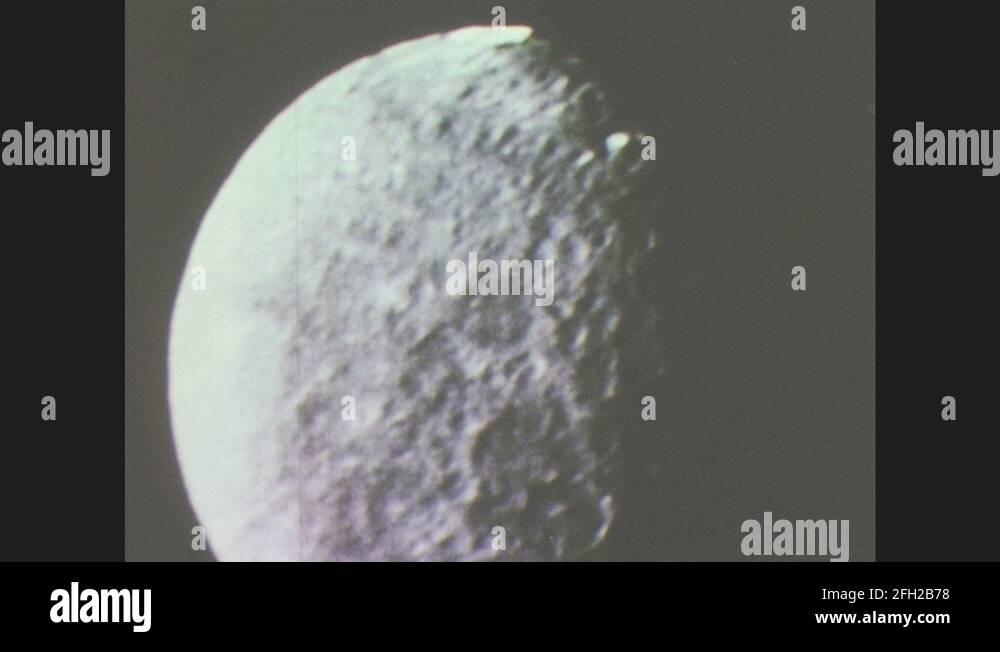 1980s: Men look at image of Uranus' moon Umbriel. Man gestures at ...