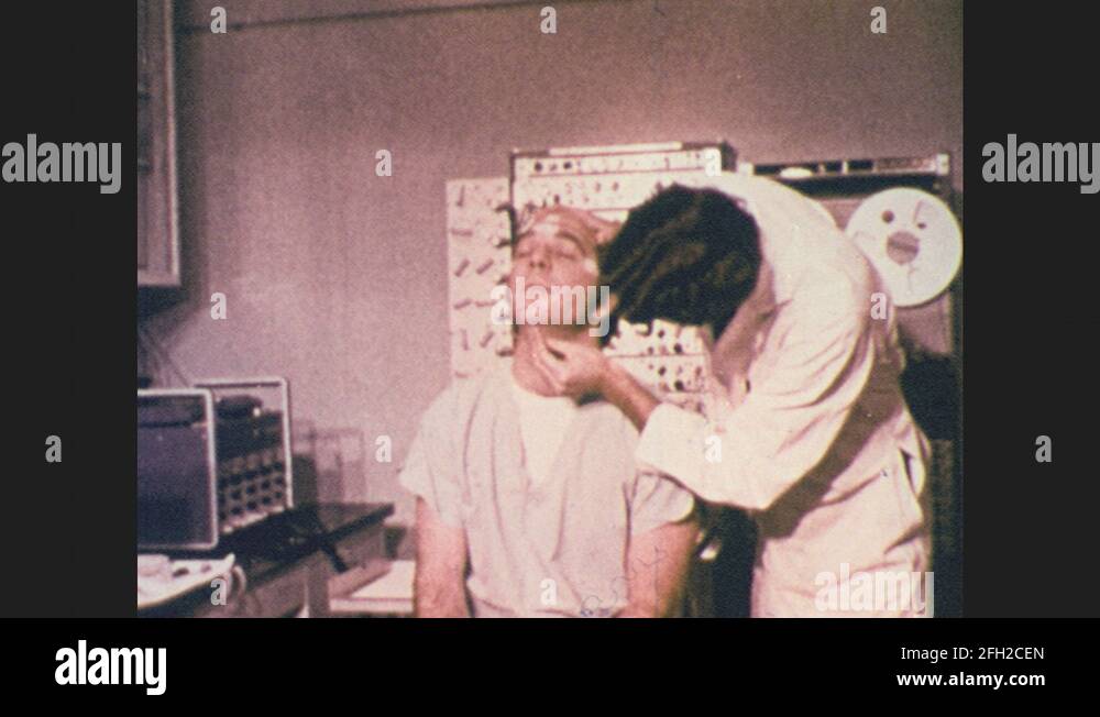 1980s: man in lab coat applies sensors to face of patient on stool in ...