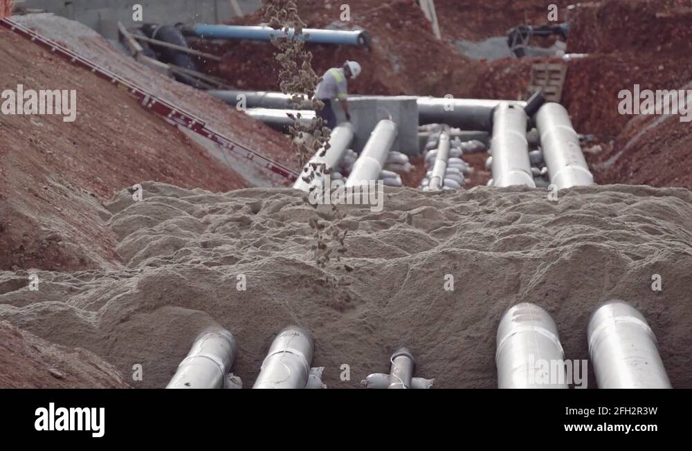 Dirt And Sand Is Dropped Onto Pipes At A Construction Site While ...