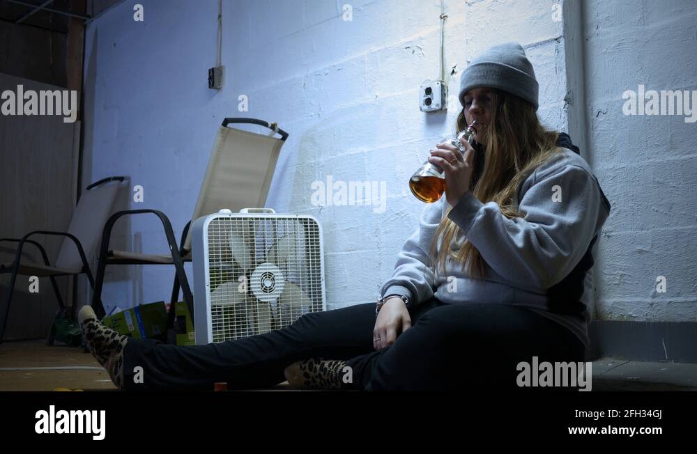 A Woman with an alcohol addiction drinks liquor in a trap house ALT ...