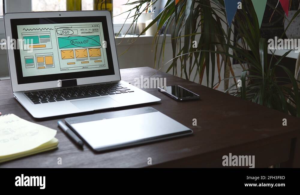 Web developer sitting at the table making a sketch of the future site ...