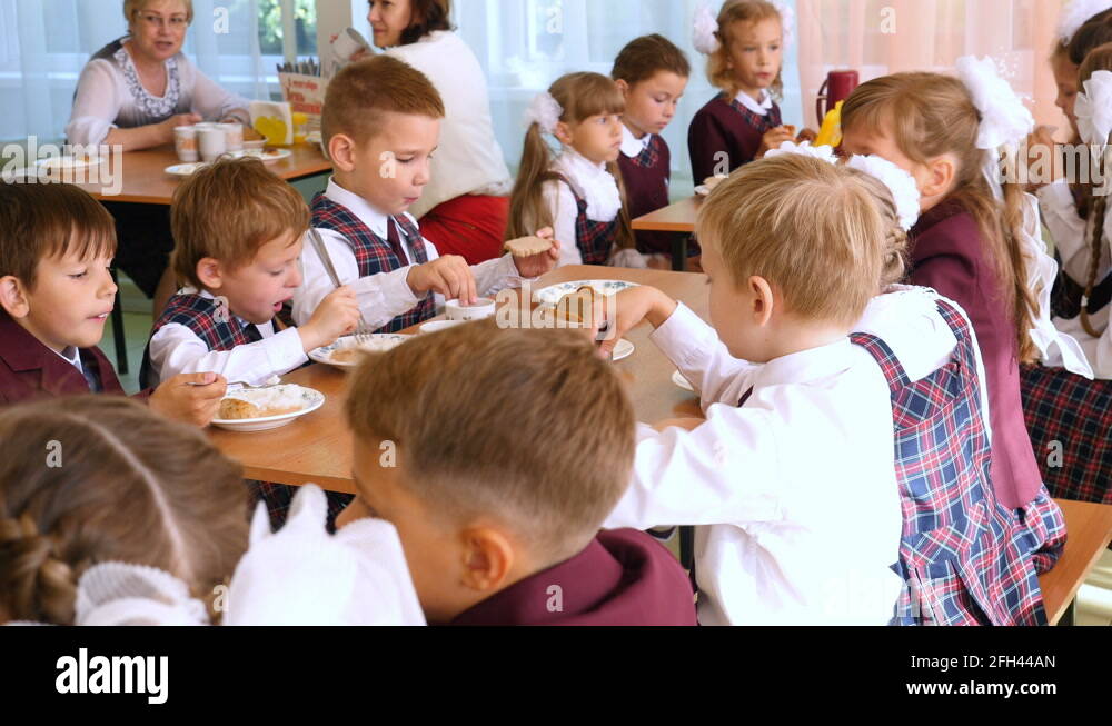School food - a group of elementary school kids eating a school ...