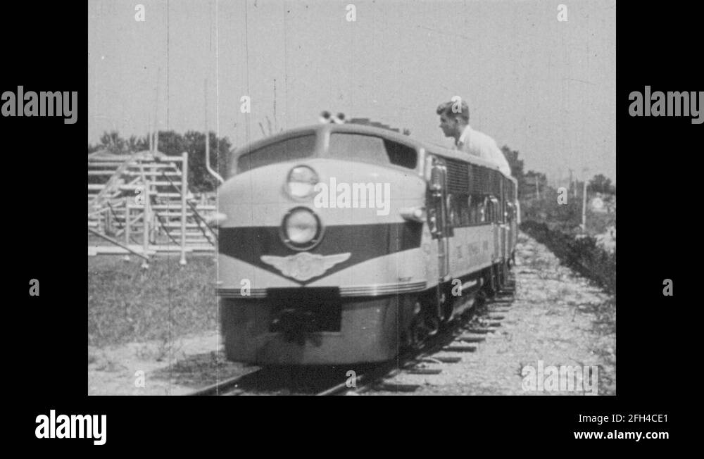 1950s: Children ride an outdoor miniature railroad. Young boy steers ...