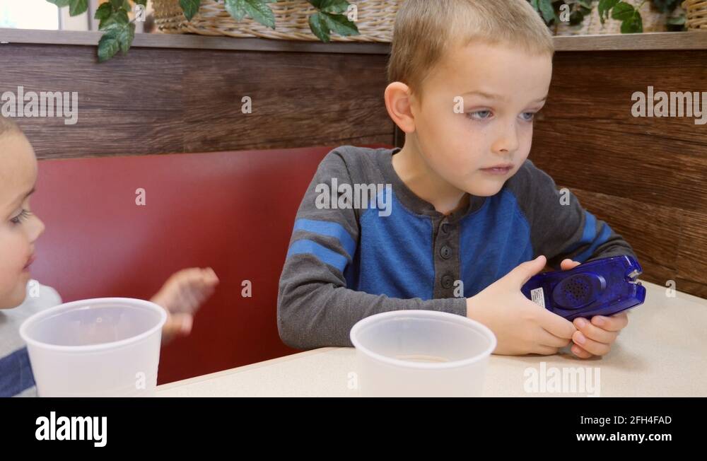 Boys waiting with a buzzer in fast food restaurant for their food Stock ...