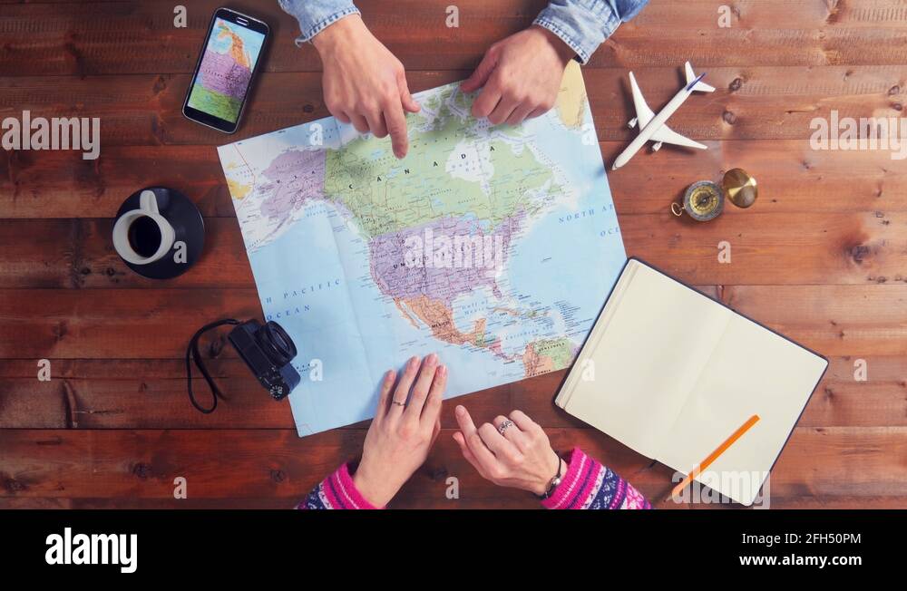 hands on world map showing trip route Stock Video Footage - Alamy