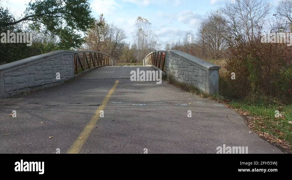 Running Over Bridge In Park With Street Art Footprints On Ground 4K ...