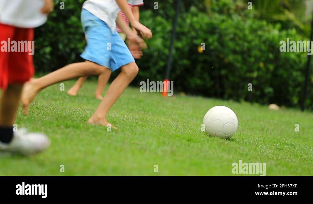 Children running after soccer ball. Kids playing football on the home ...