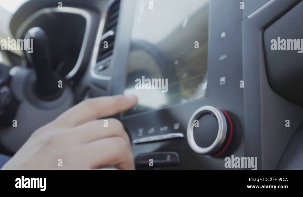 The driver presses the touch screen in the car. The man thumbs the menu ...