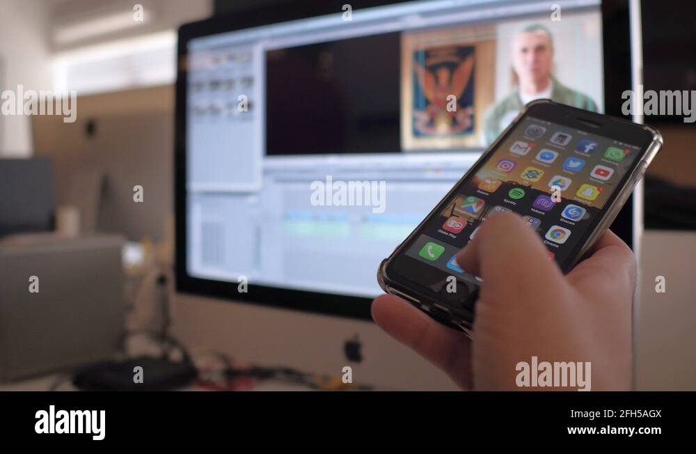 Woman checks her Gmail account on her mobile phone in an office setting ...
