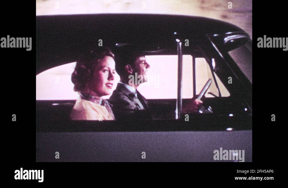 1950s: Man driver and woman passenger smile and look ecstatic to be ...