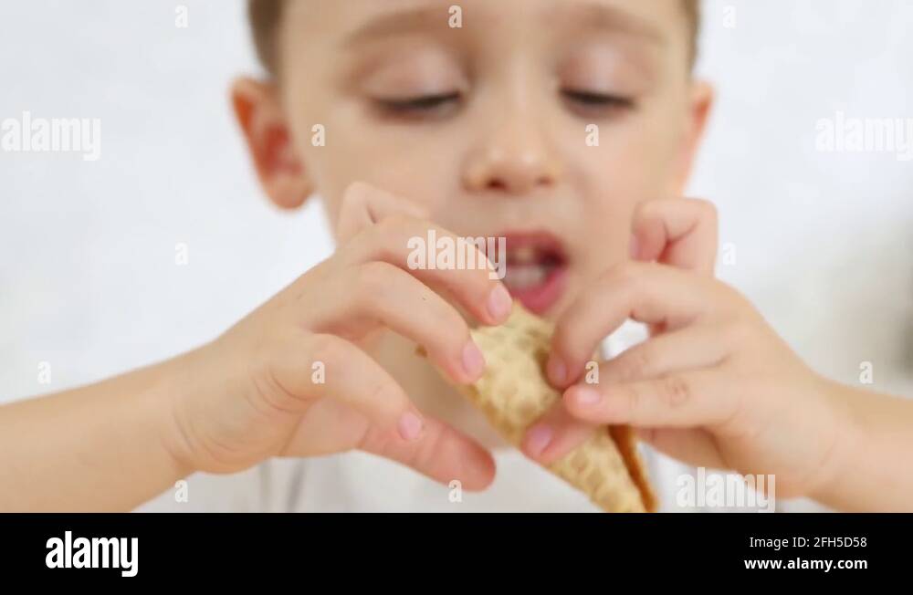 A child is happy to eat a chocolate cone of ice cream in a waffle cone ...