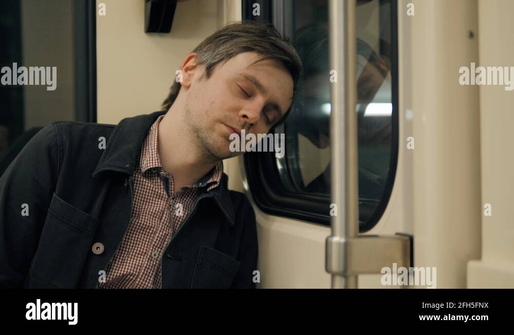 man sleeping in a underground Metro subway train. Tired worker student ...