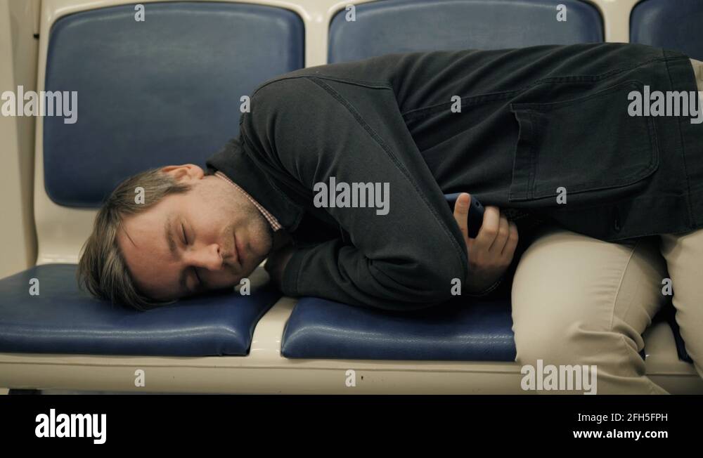 man sleeping in a underground Metro subway train. Tired worker student ...