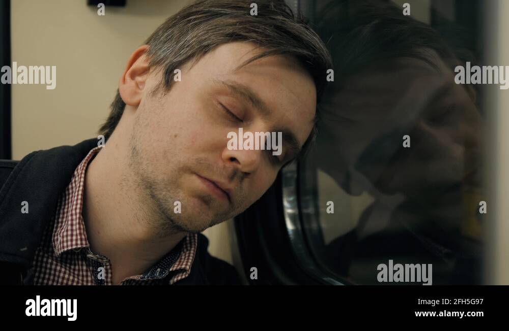 man sleeping in a underground Metro subway train. Tired worker student ...