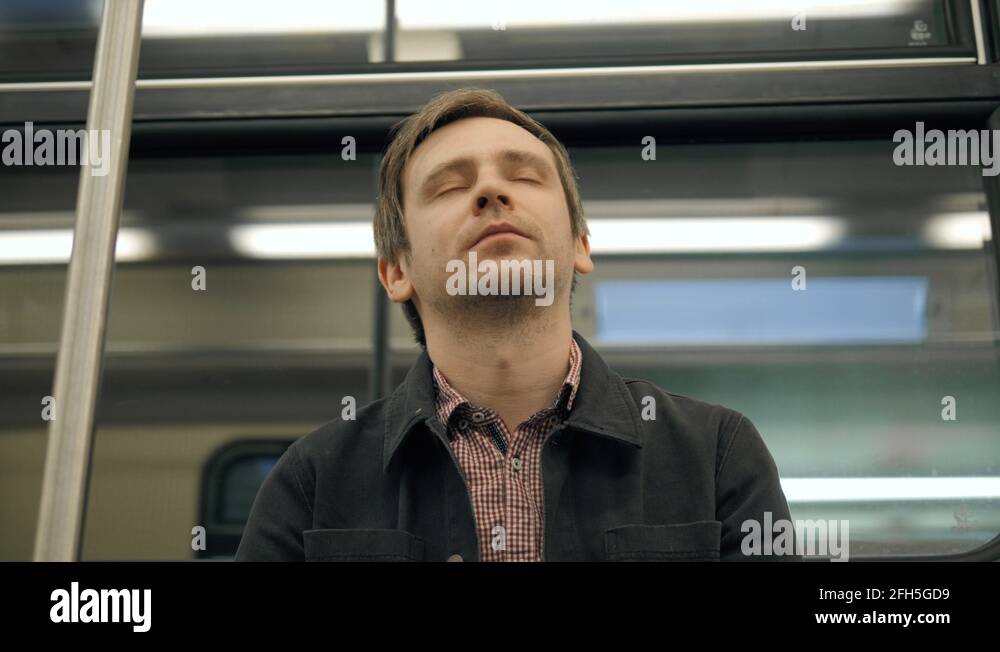 man sleeping in a underground Metro subway train. Tired worker student ...