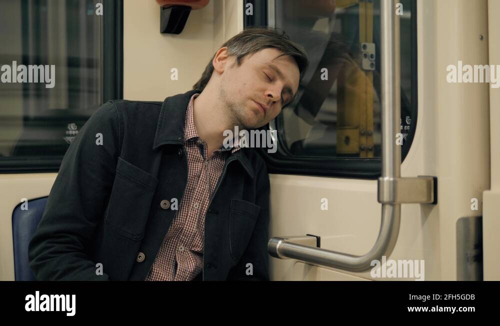 man sleeping in a underground Metro subway train. Tired worker student ...