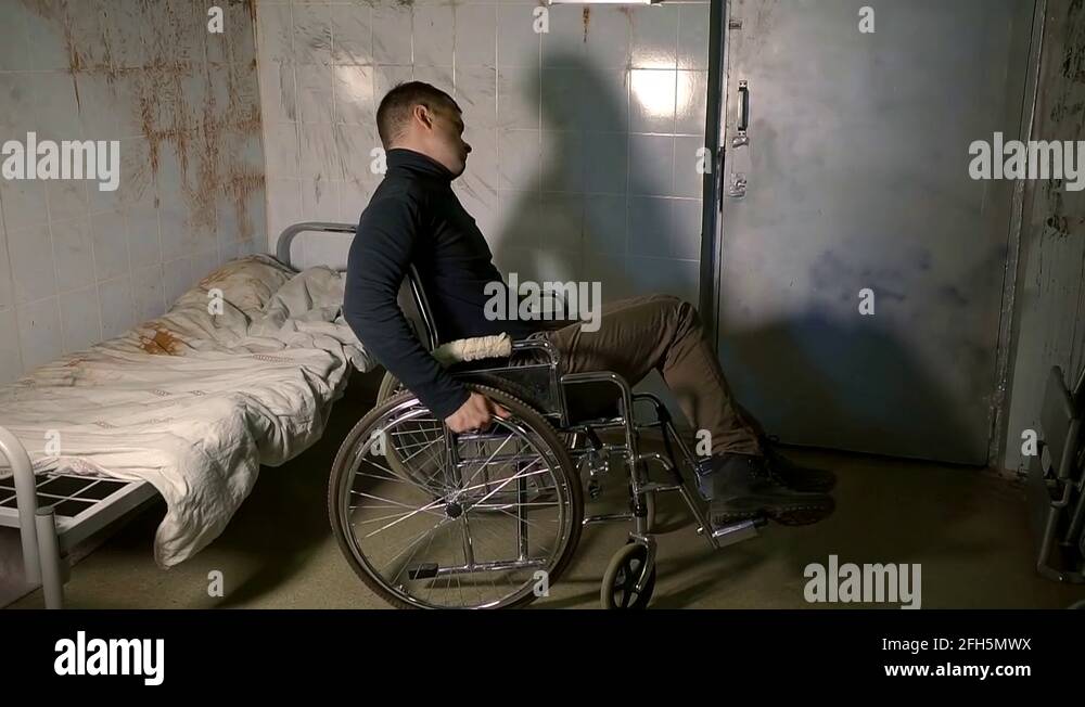 male disabled wheelchair user is whirling in a hospital room with dirty ...