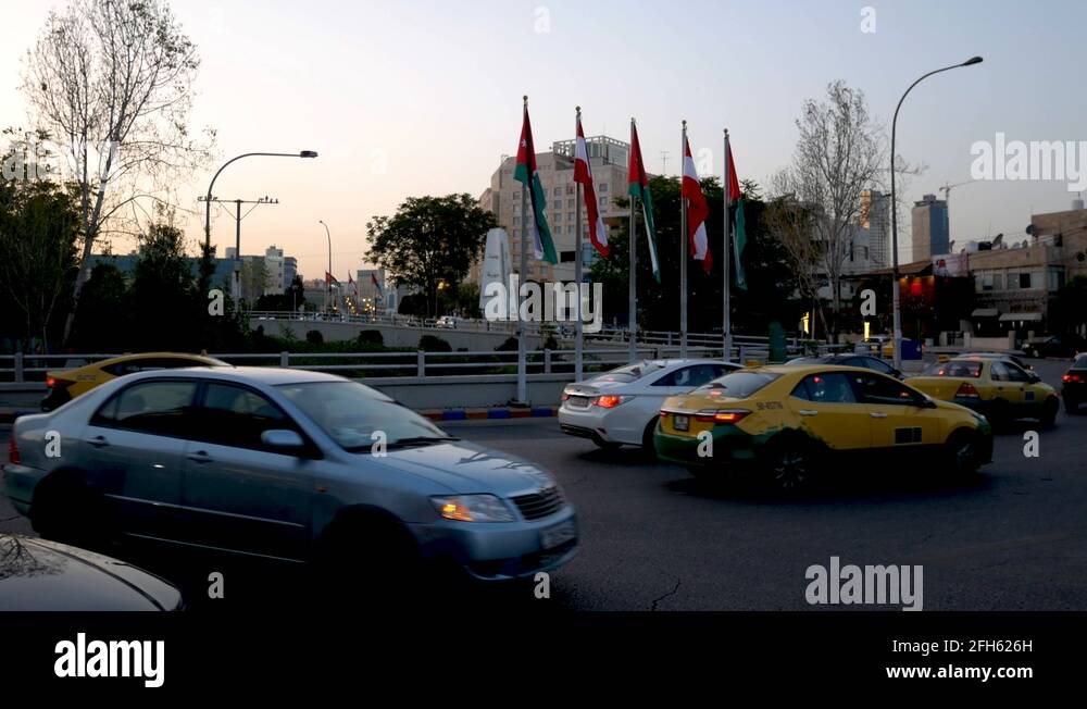 Evening vehicular traffic at a busy intersection in downtown Amman ...