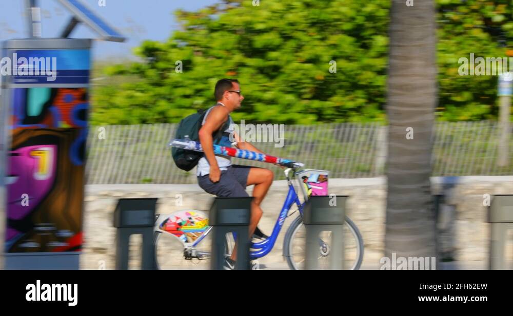 Man riding bike Miami Beach far telephoto tracking footage 4k Stock ...