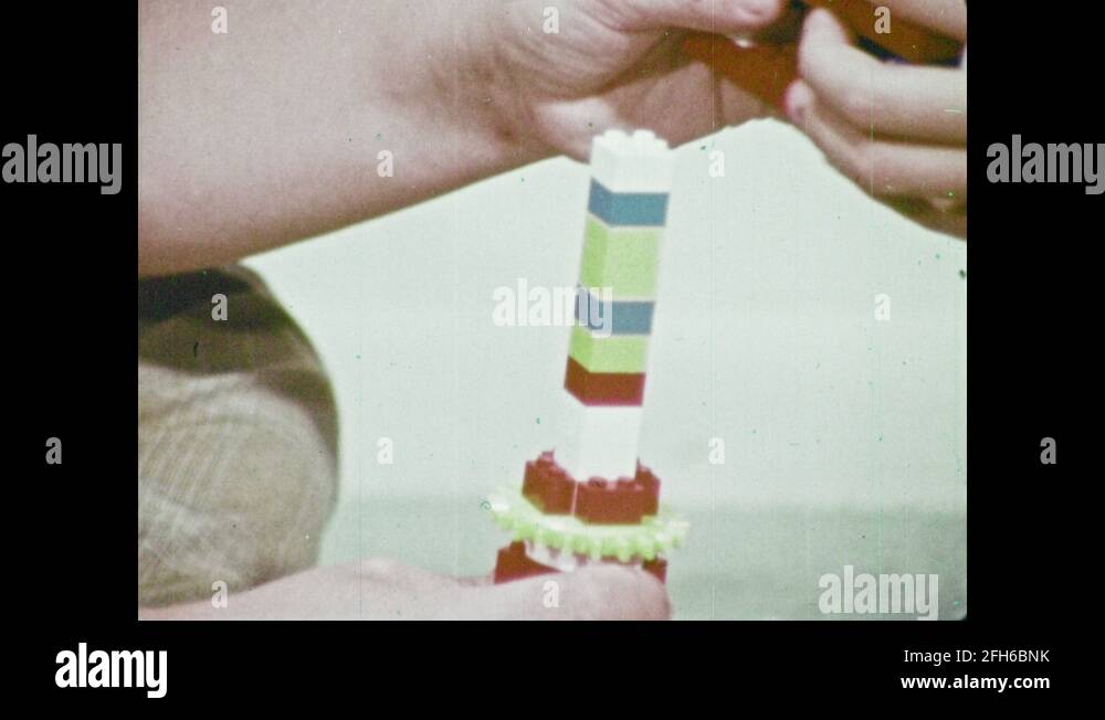 1970s: Boy snaps stacks of Legos together. Boy constructs spinning ...