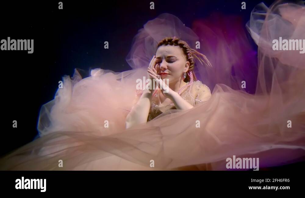 a young woman is like a sea nymph, is at the bottom of the pool, the ...