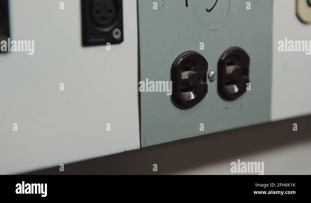 Plugging in a power cable into a power outlet on an electrical board ...