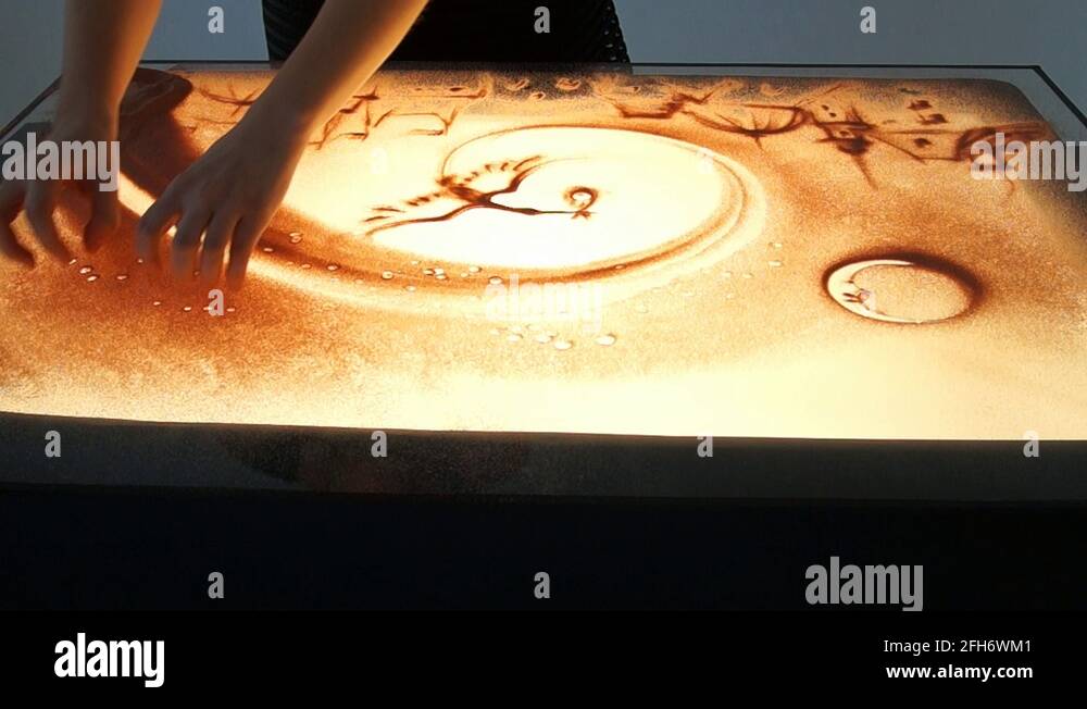 Drawing with sand. Drawing sand on a white screen. Sand Artist. Hands ...
