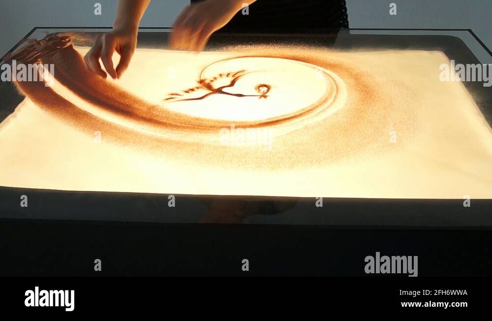 Drawing with sand. Drawing sand on a white screen. Sand Artist. Hands ...