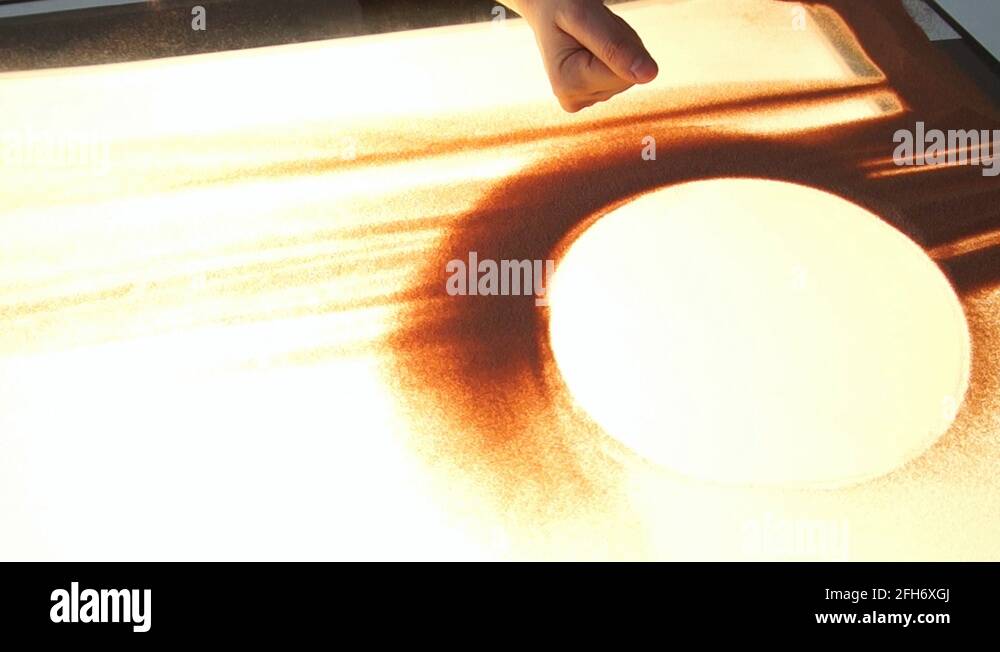 Drawing with sand. Drawing sand on a white screen. Sand Artist. Hands ...