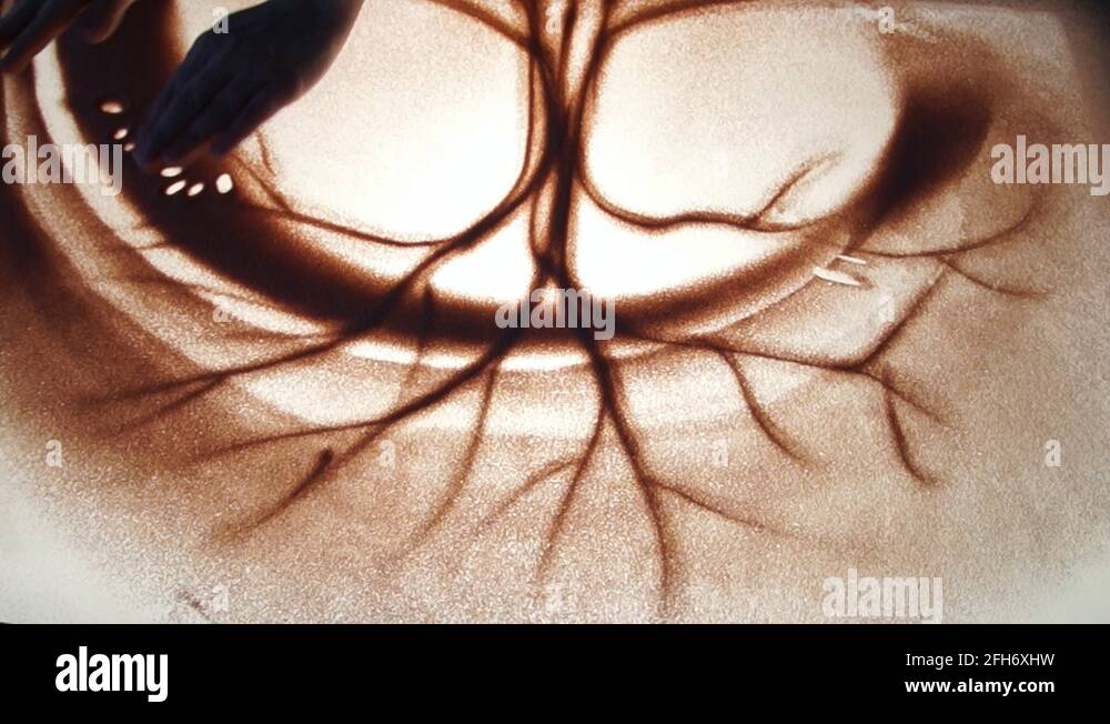 Drawing with sand. Drawing sand on a white screen. Sand Artist. Hands ...